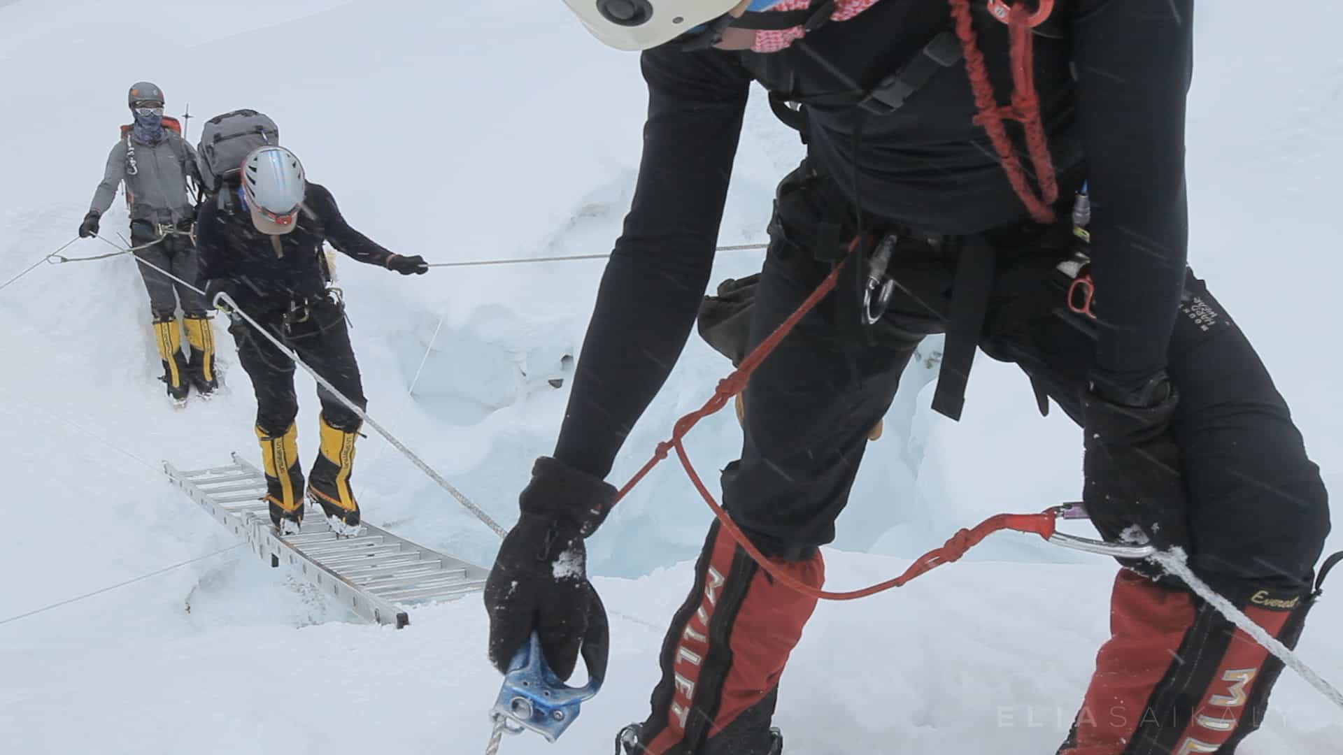 Team crossing a ladder in the Khumbu Icefall - Elia Saikaly Licensing